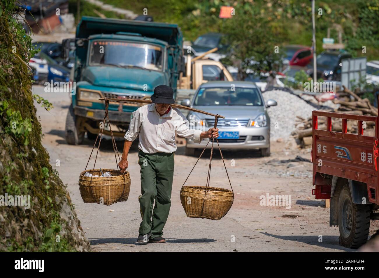 Pingan, China - August 2019 : Old Chinese man carrying heavy load of ...