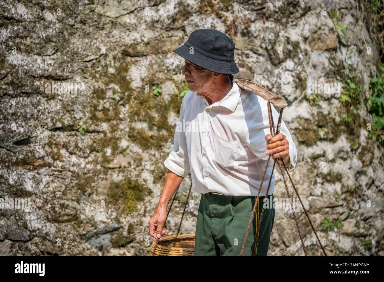 Pingan, China - August 2019 : Old Chinese man carrying heavy load of ...