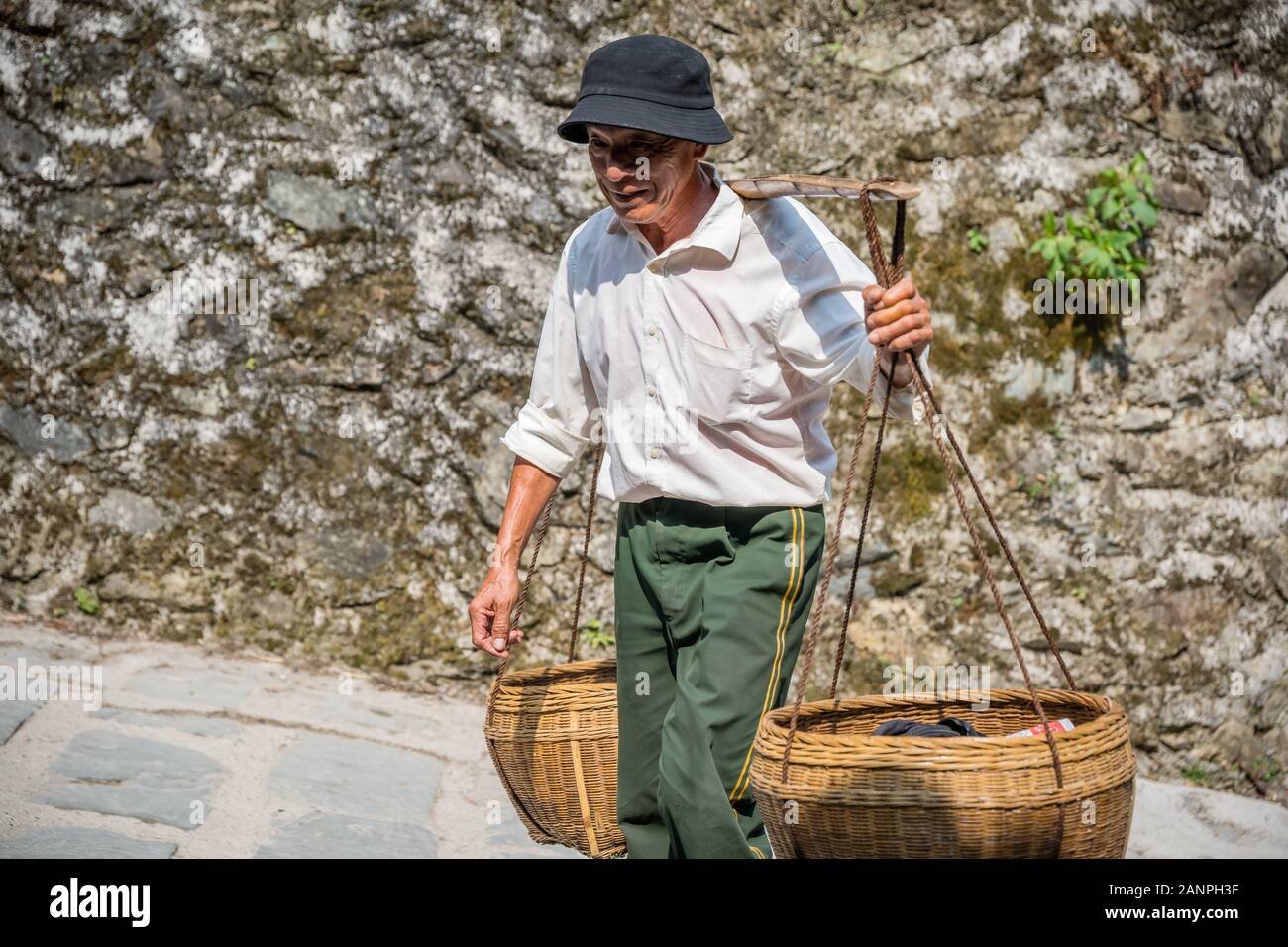 Pingan, China - August 2019 : Old Chinese man carrying heavy load of ...