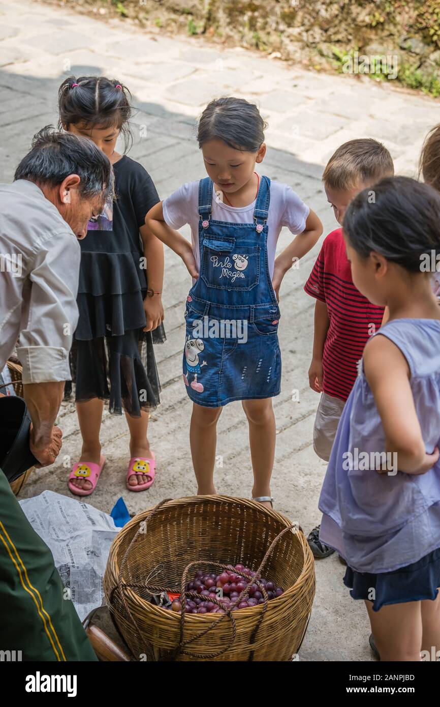 Pingan, China - August 2019 : Curious village children looking inside ...