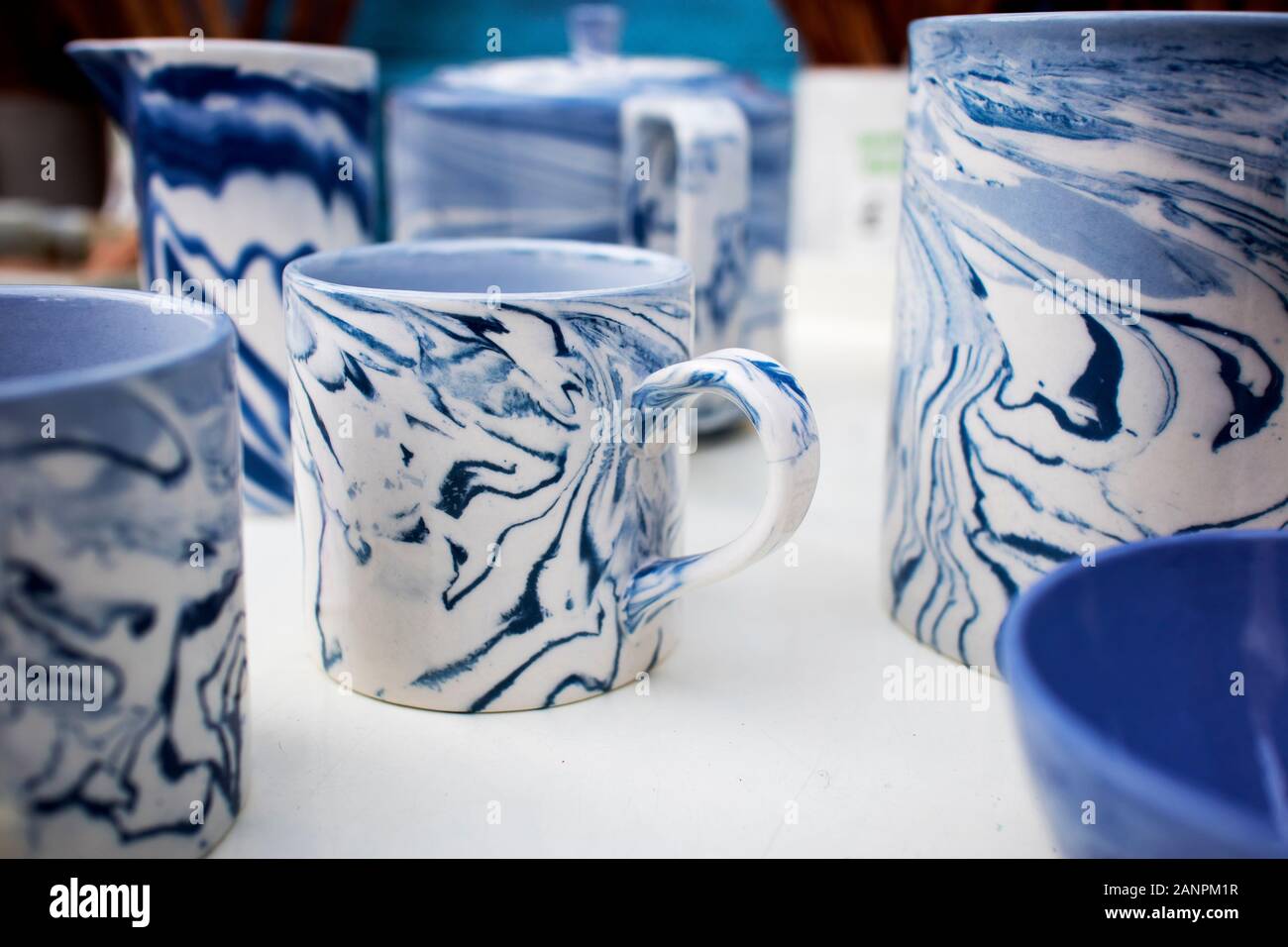 White faience mugs with blue stains on a table for sale. Handmade Stock ...