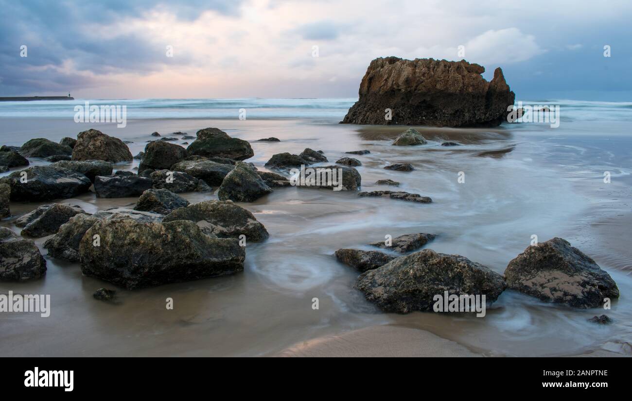 Waves rocks and sunset on the beach Stock Photo - Alamy
