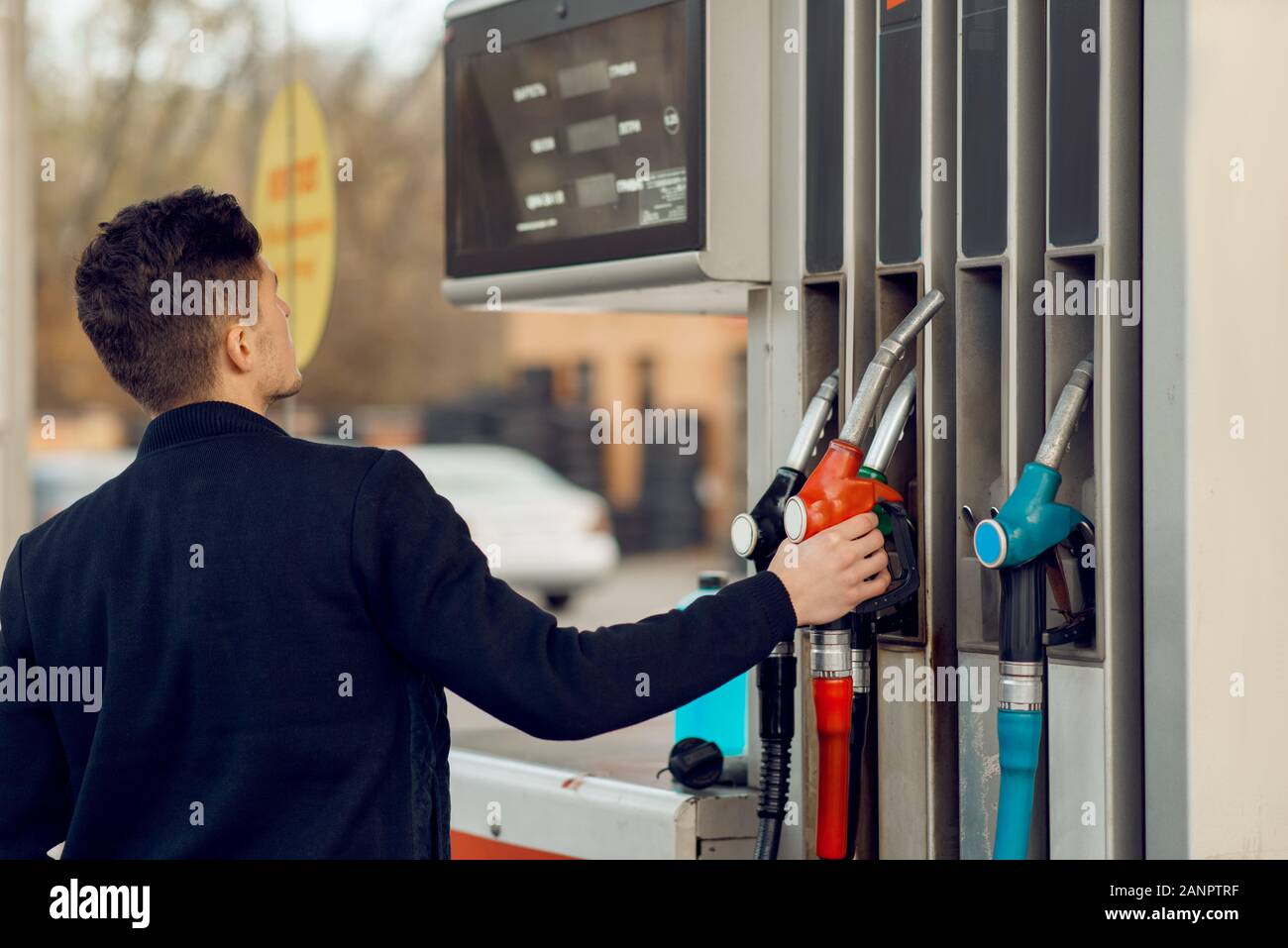 Man takes the gun on gas station, fuel filling Stock Photo - Alamy