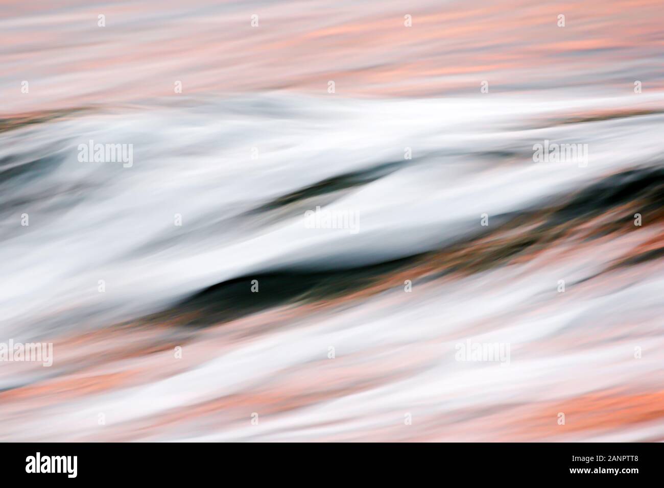 A blurred, muted wave showing reflections of a sunset in Costa Rica ...