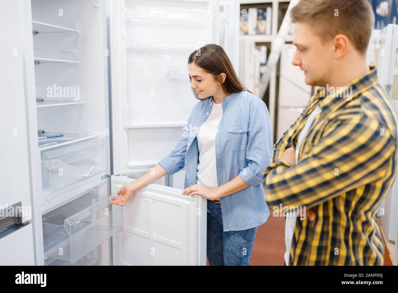 Couple choosing refrigerator in electronics store Stock Photo - Alamy