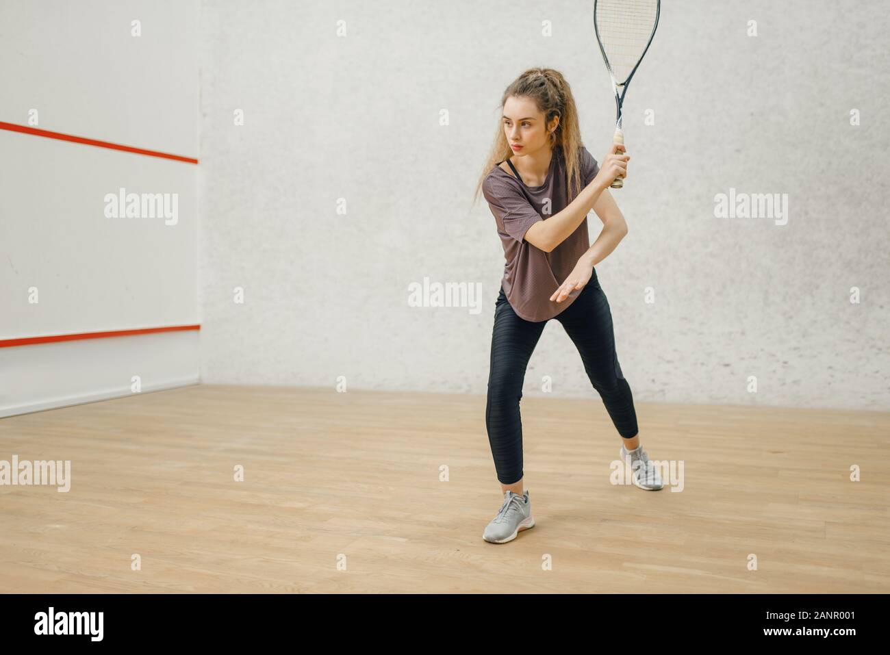 Female player with squash racket in action Stock Photo - Alamy