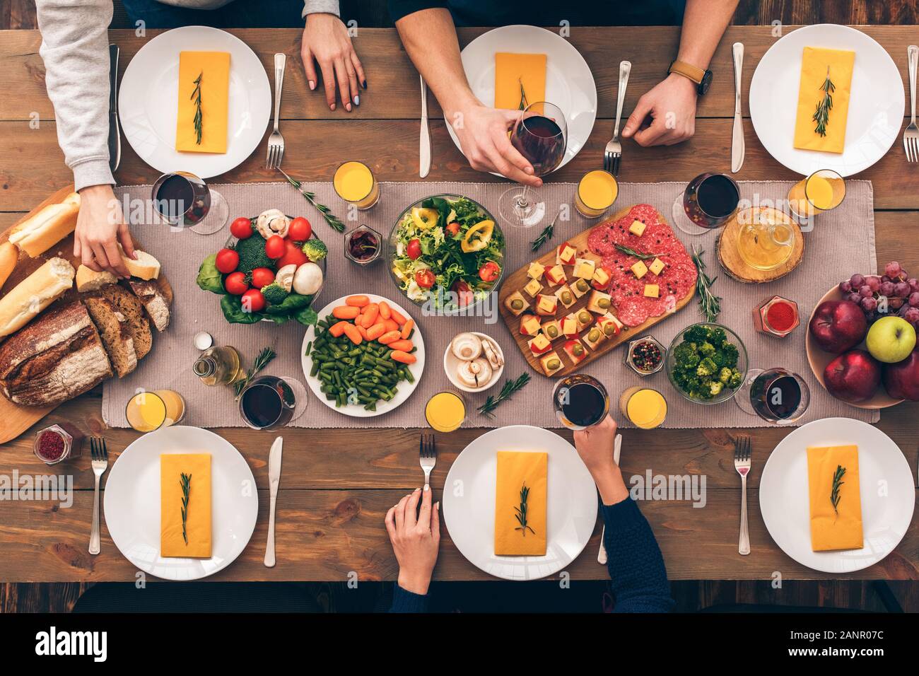 People sitting at home behind table with food Stock Photo - Alamy