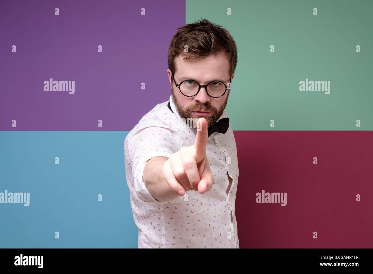 Stern man with round glasses makes a stop gesture with index finger ...