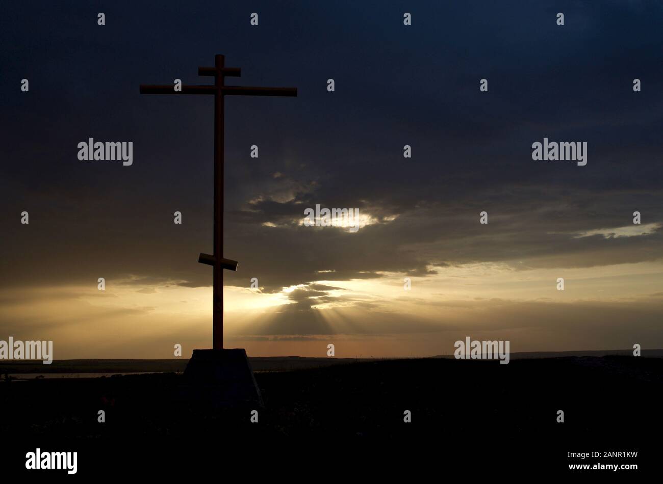 The Orthodox cross against the sunset sky rays of the sun sneaks ...