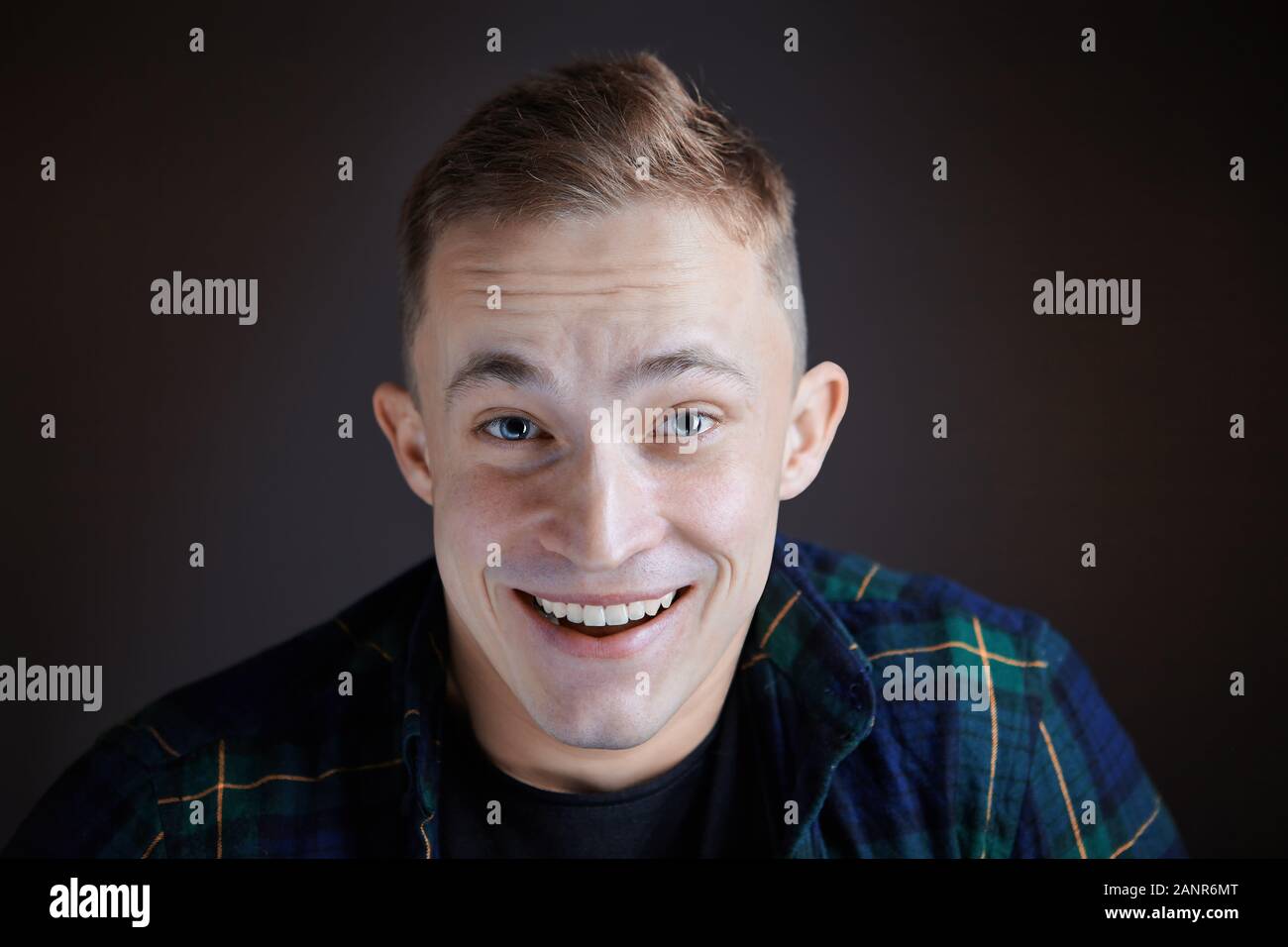 A surprised smile on the face of a young Caucasian man who is see a ...