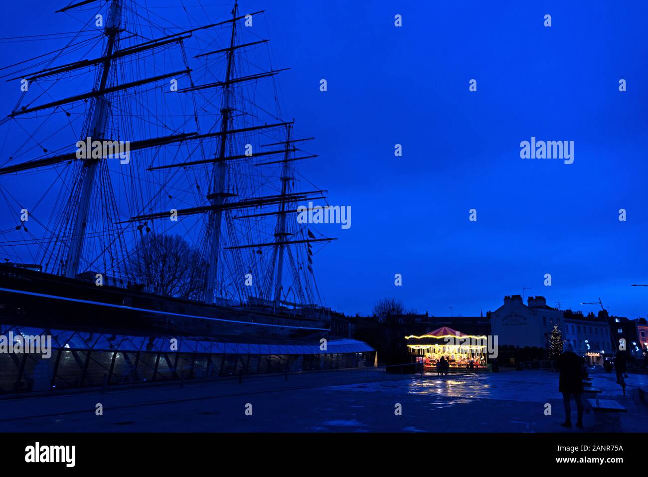 Lights of a carousel glowing in the winter dusk are dwarfed by the ...