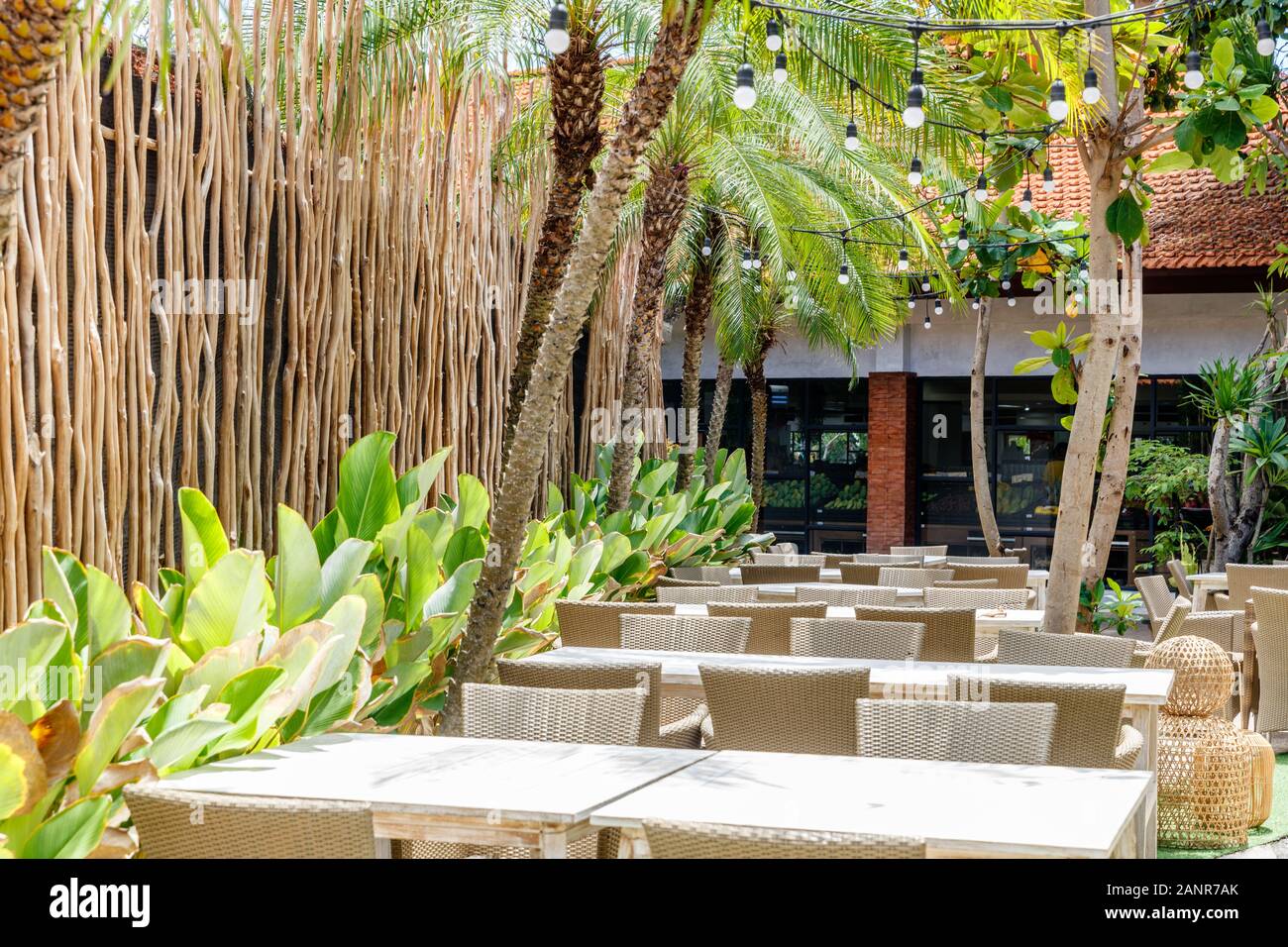 Tables and chairs at a green outdoor cafe. Nusa Dua, Bali, Indonesia ...