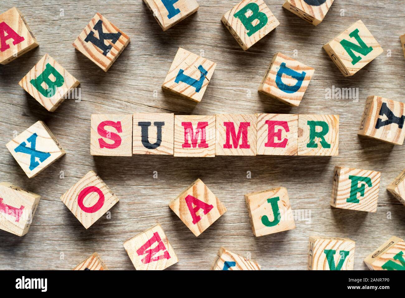 Letter block in word summer with another alphabet on wood background ...