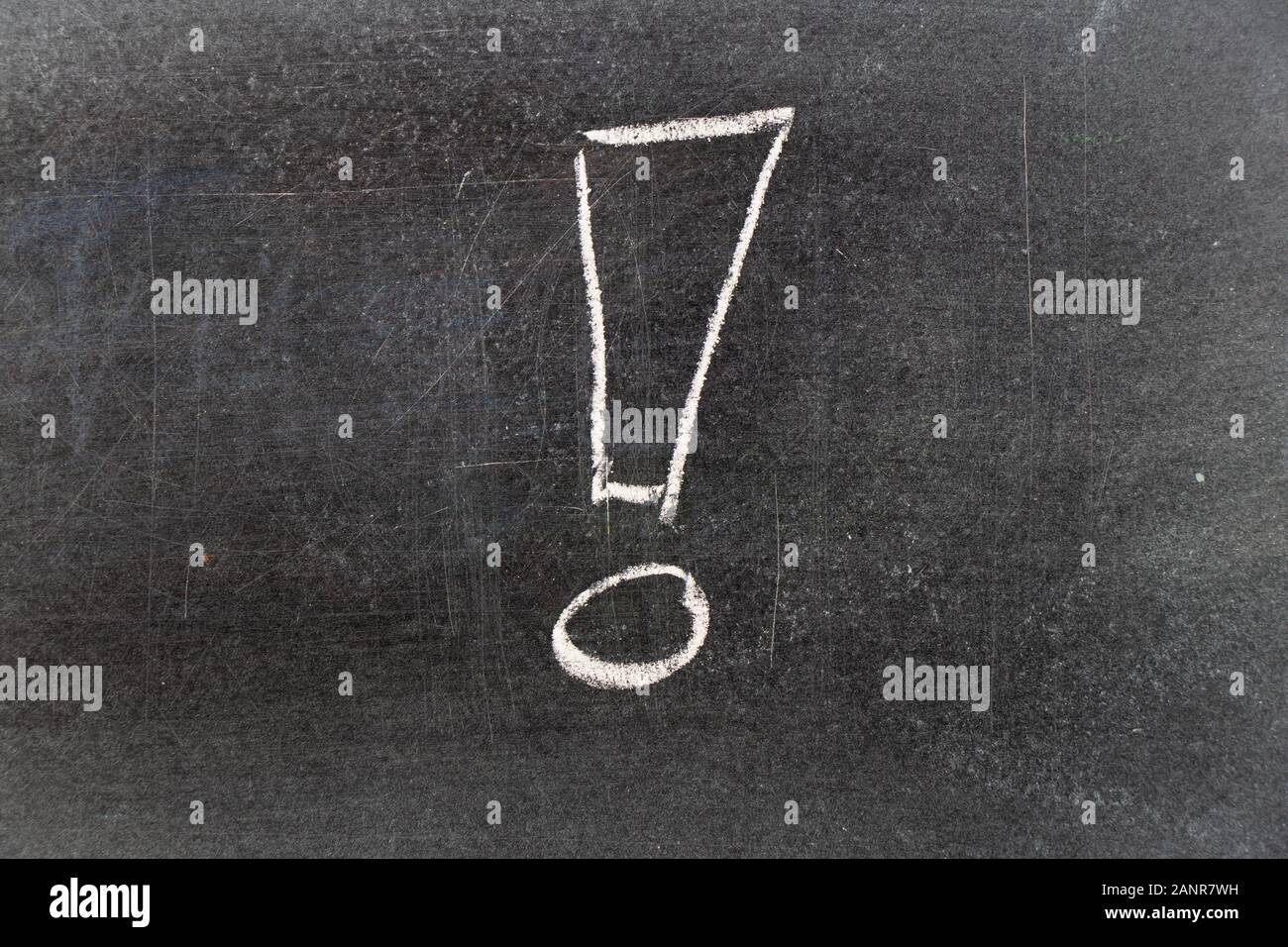 White color chalk hand drawing in exclamation mark with blank space ...