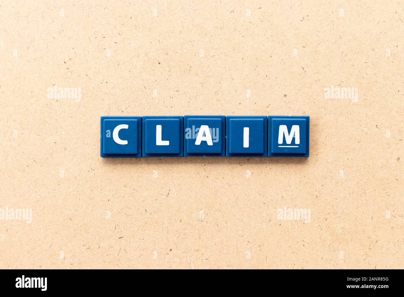 Tile letter in word claim on wood background Stock Photo - Alamy