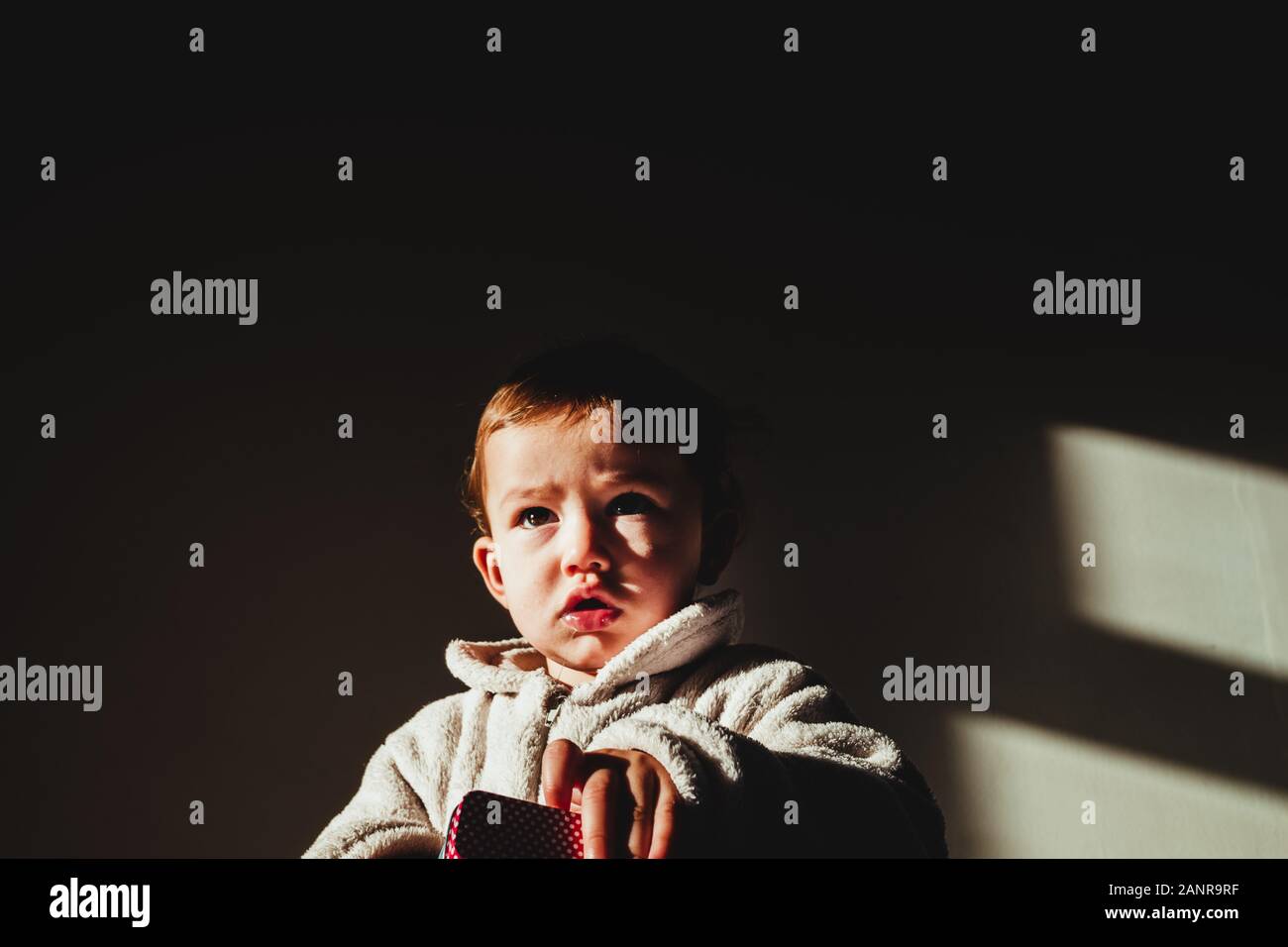 Portrait of serious baby isolated with dark background Stock Photo - Alamy