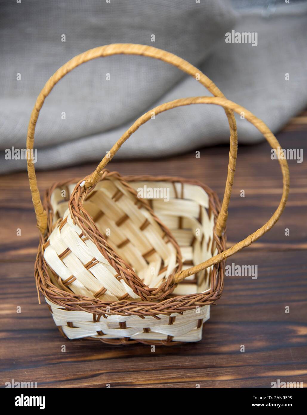 Two empty wicker small baskets on a wooden table top Stock Photo - Alamy