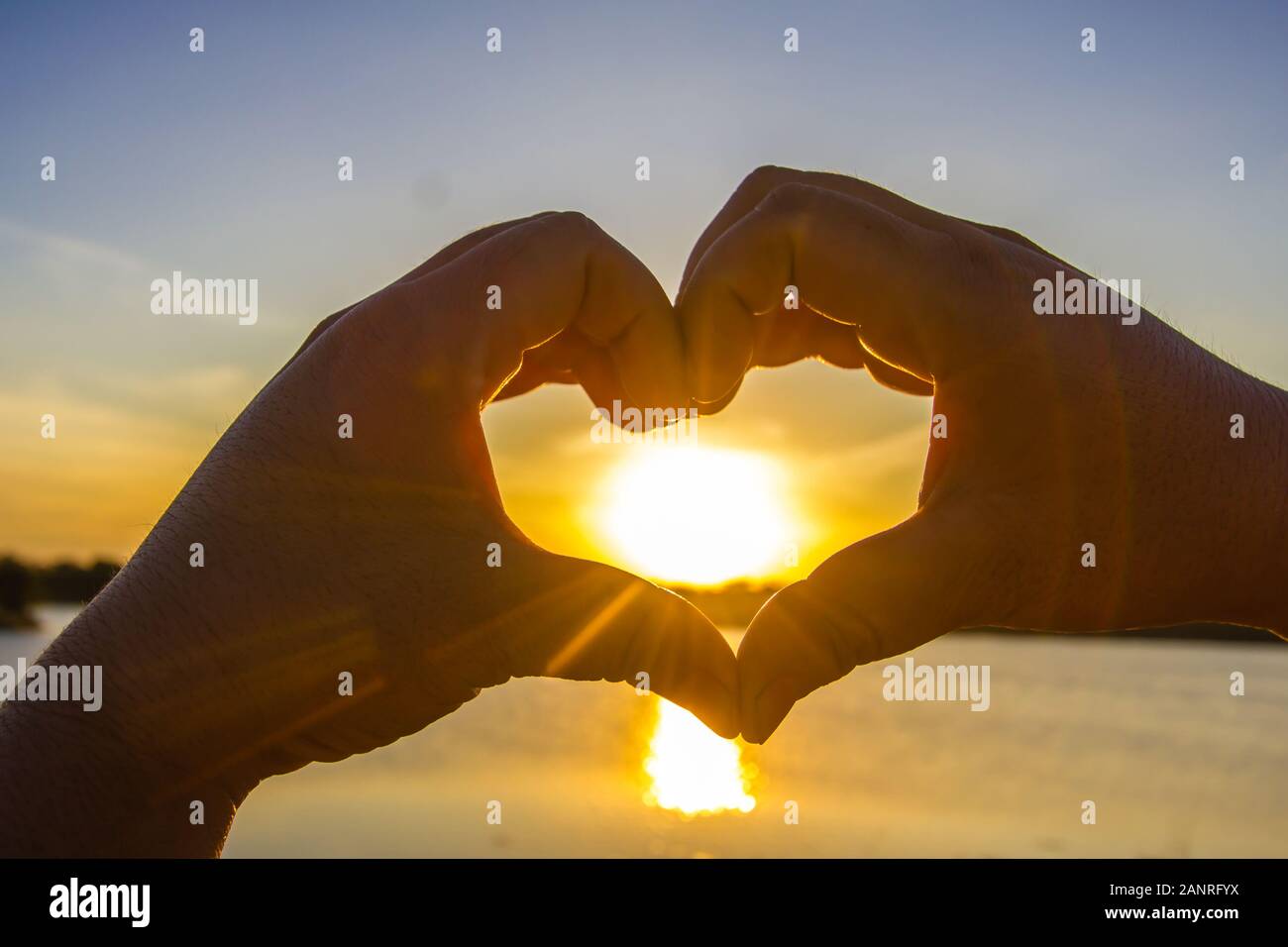 Hands making the shape of a heart with the sun in the middle Stock ...