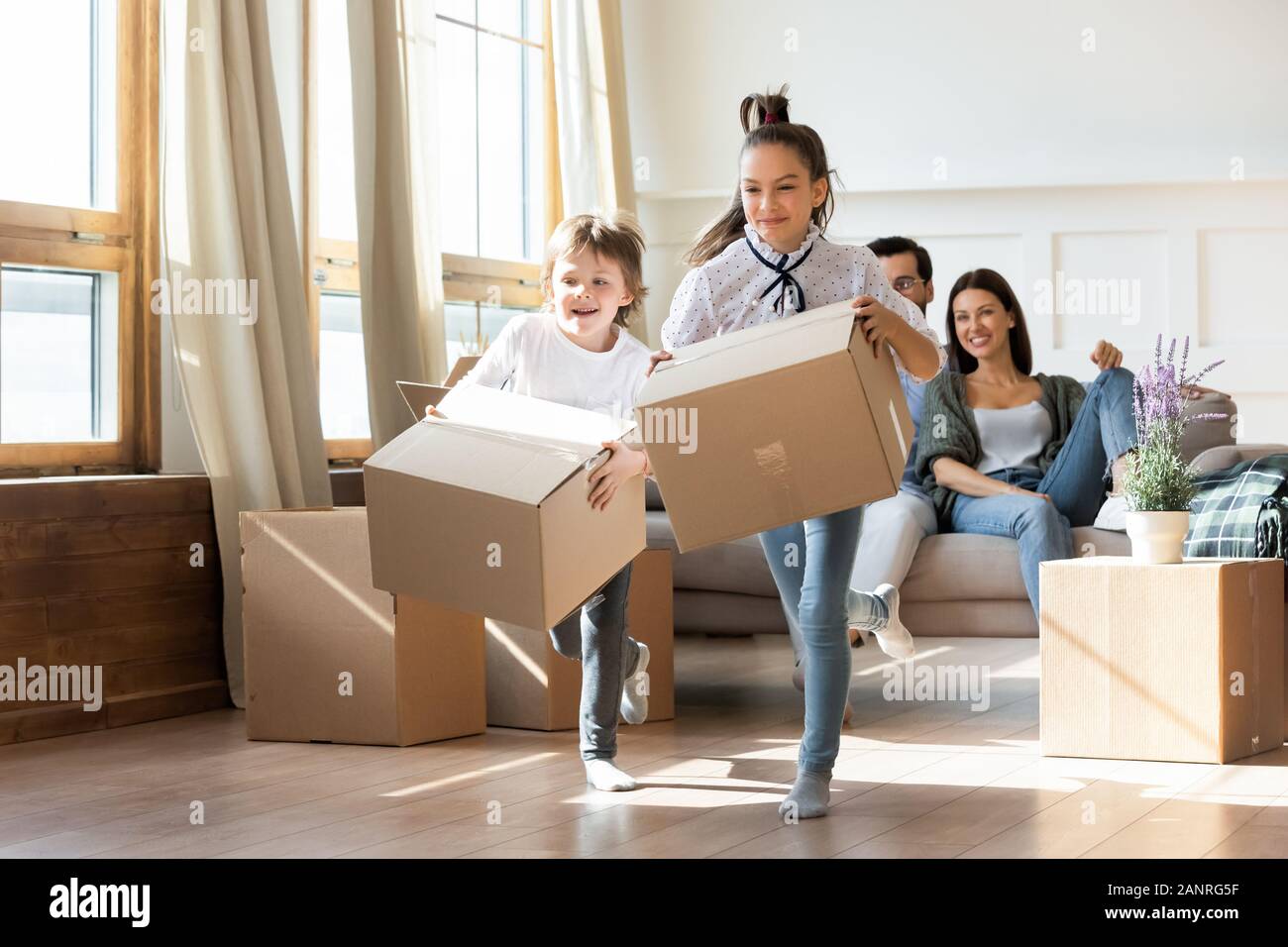 Excited kids have fun unpacking boxes on moving day Stock Photo - Alamy