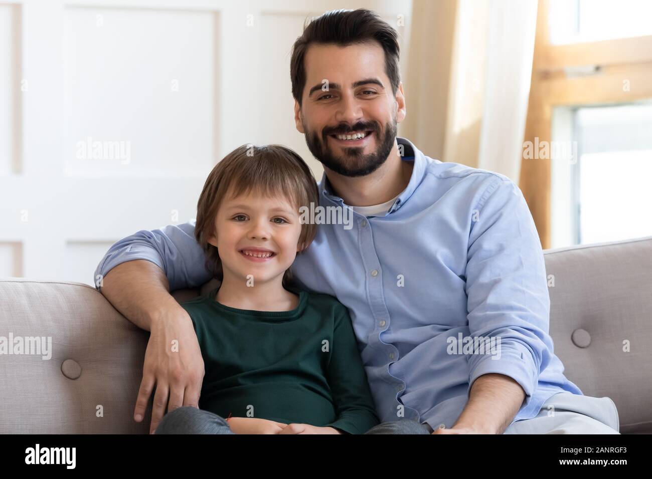 Portrait of happy dad and little son relax on couch Stock Photo - Alamy