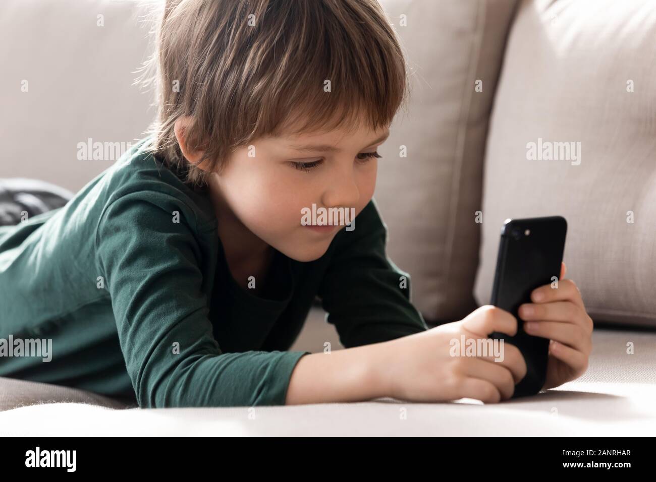 Smart little boy have fun watching video on cellphone gadget Stock ...