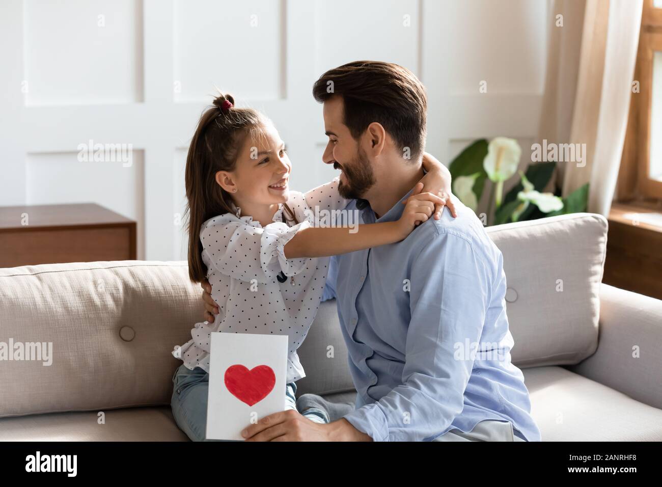 Cute little girl hug dad greeting with handmade postcard Stock Photo ...