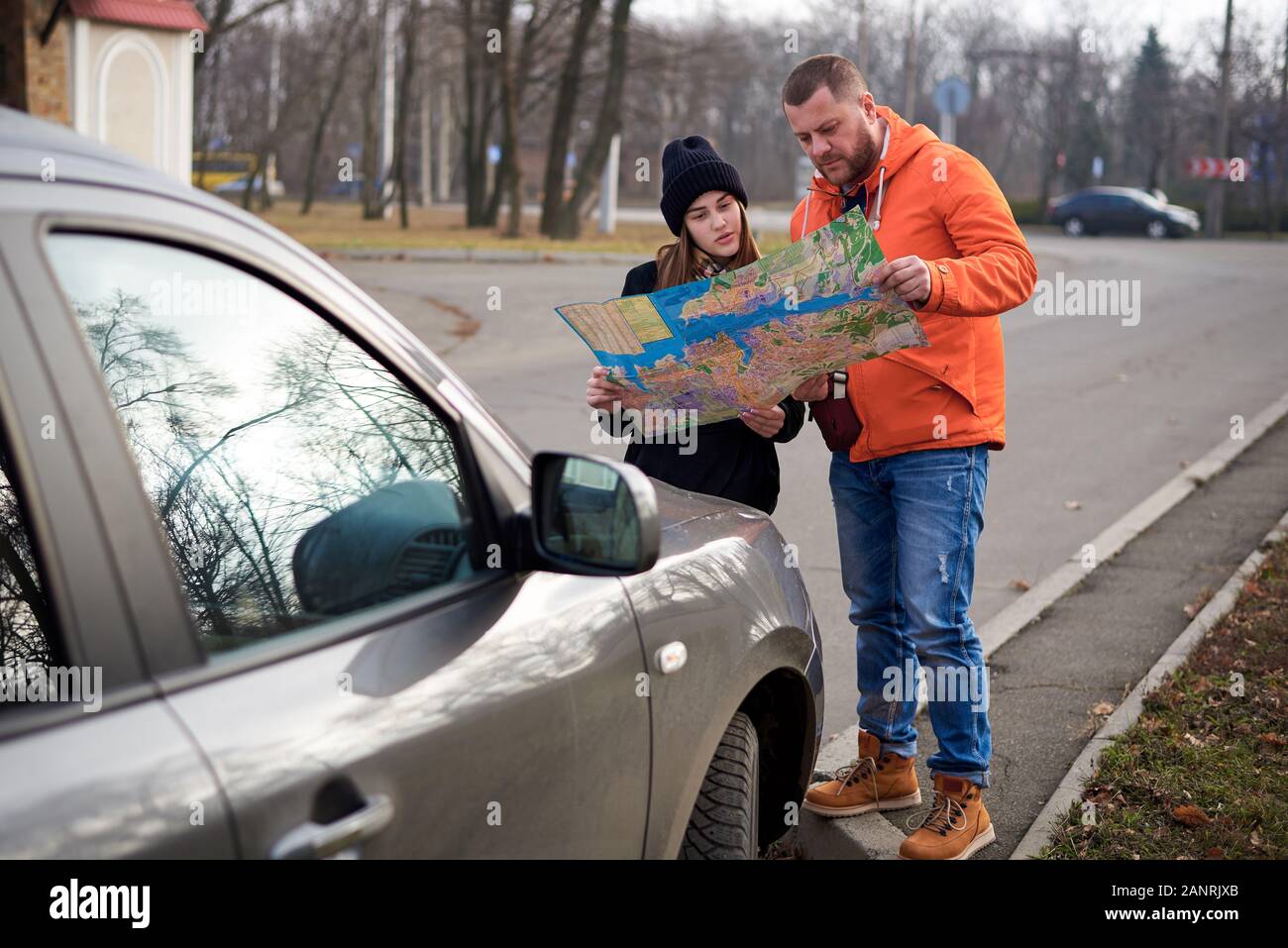 Map in the hands of young people on the road with a car Stock Photo - Alamy