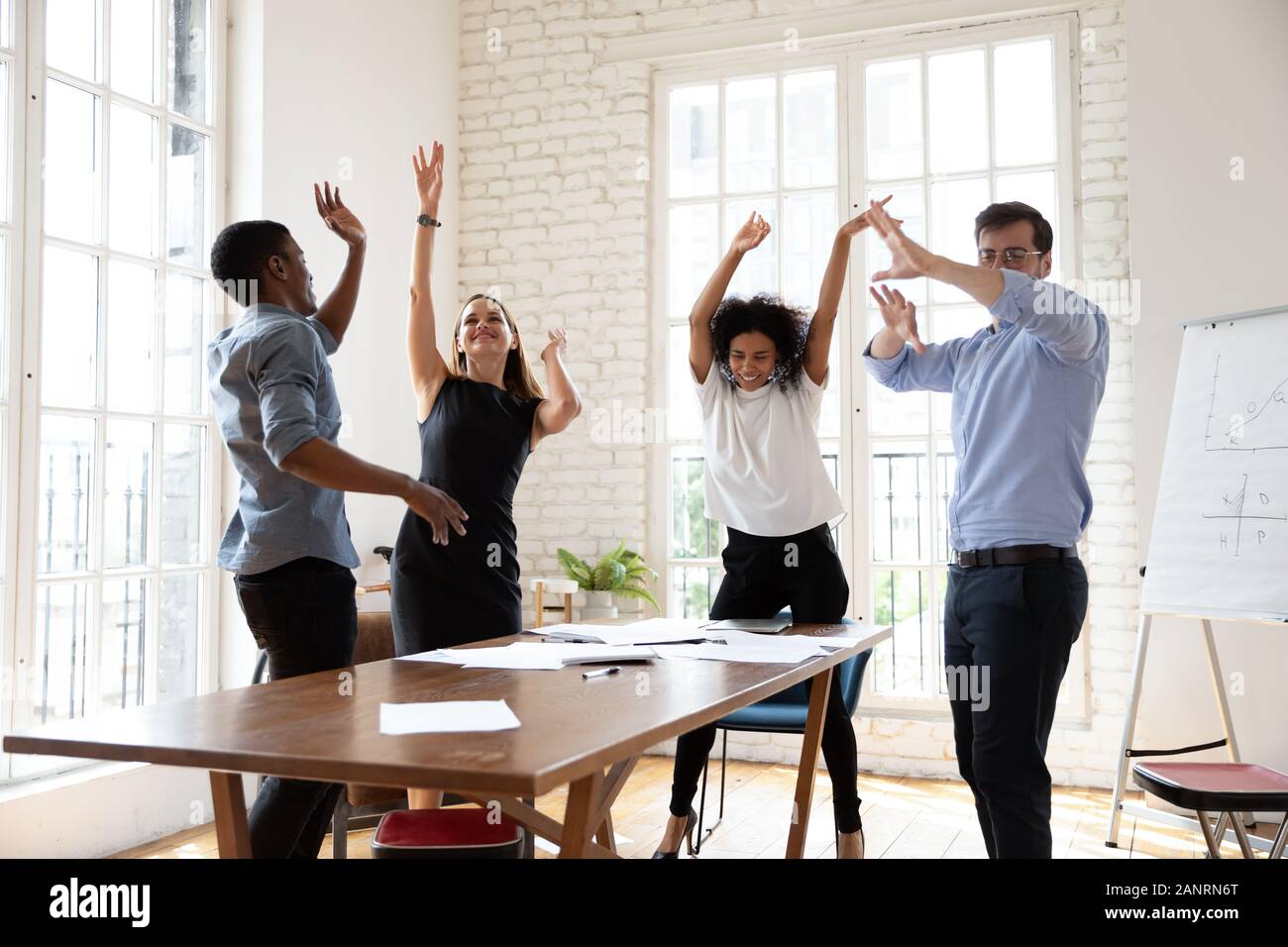 Happy business people celebrating success, dancing at meeting in ...