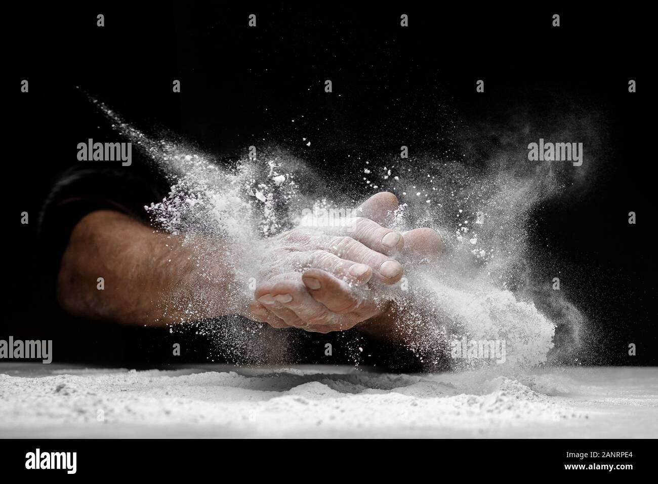 Chef clap white flour dust man hand on black background Stock Photo - Alamy