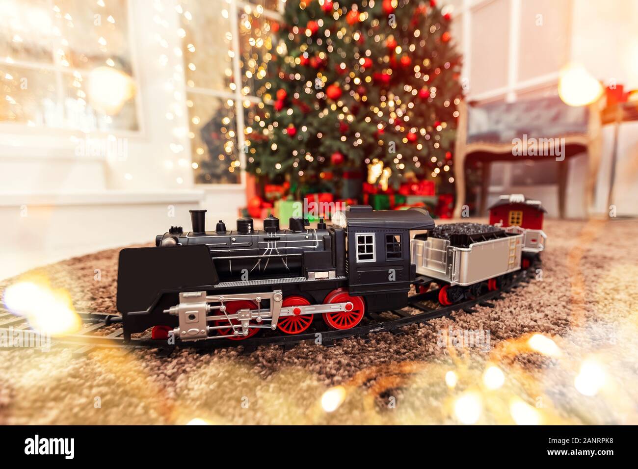 Christmas toy train steam engine with wagons in background illumination ...
