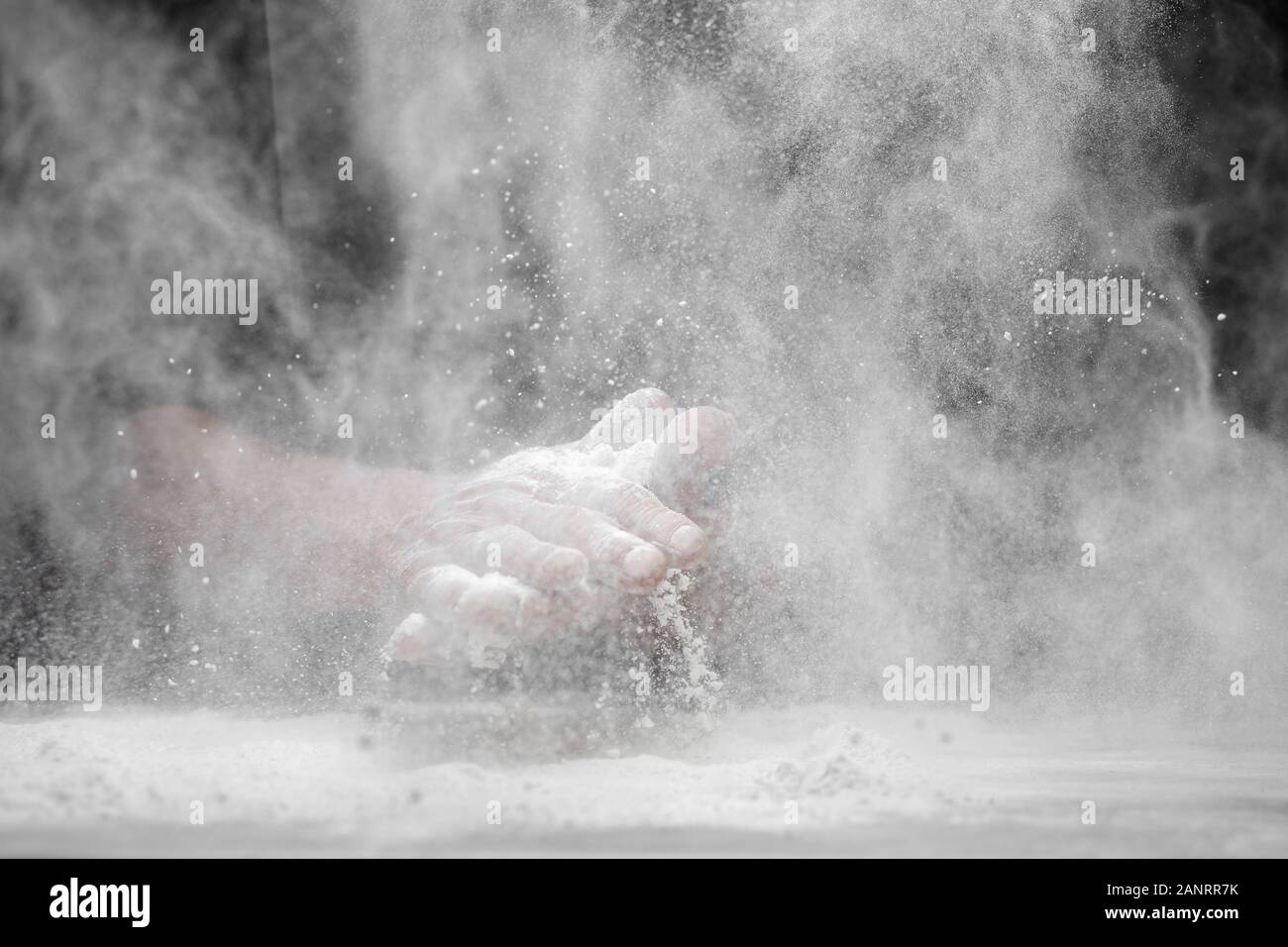 Chef man clap hand and white flour dust on black background Stock Photo ...