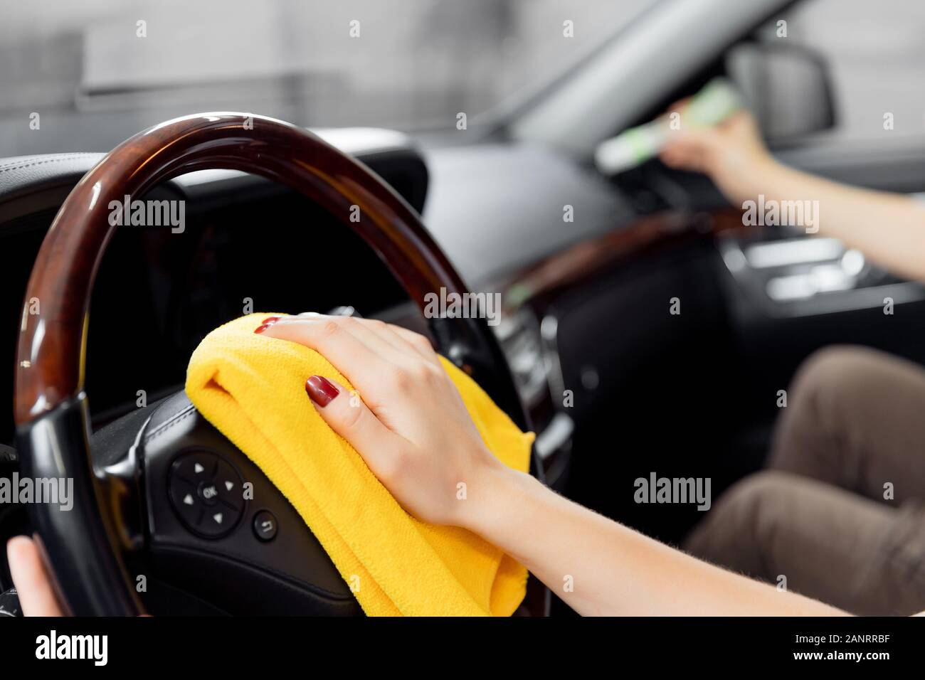 Car wash service, girl worker cleans leather surface of steering wheel ...