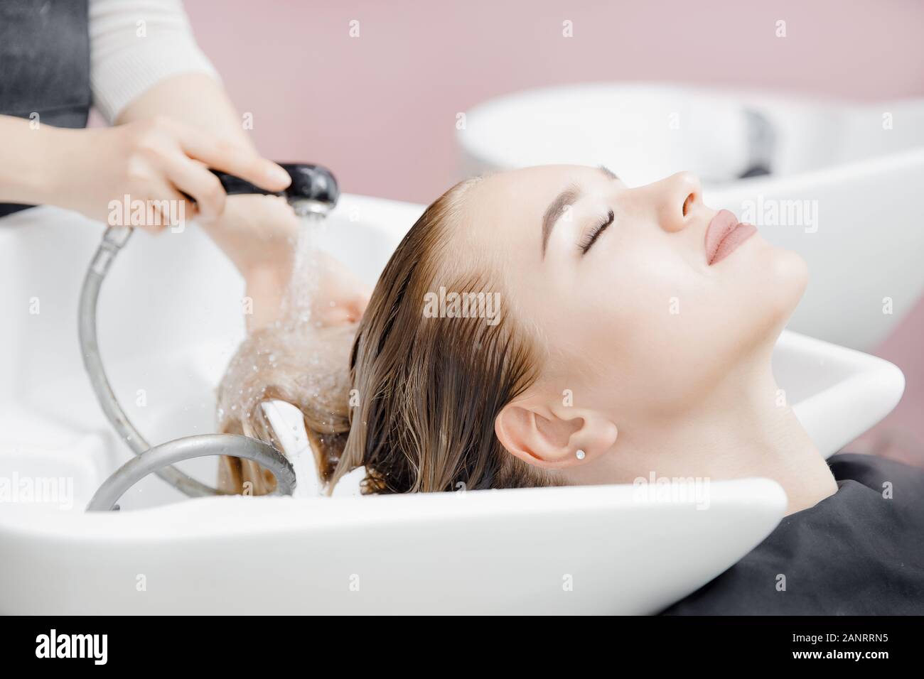 Beautiful blond woman getting hair wash in beauty salon. Concept head ...