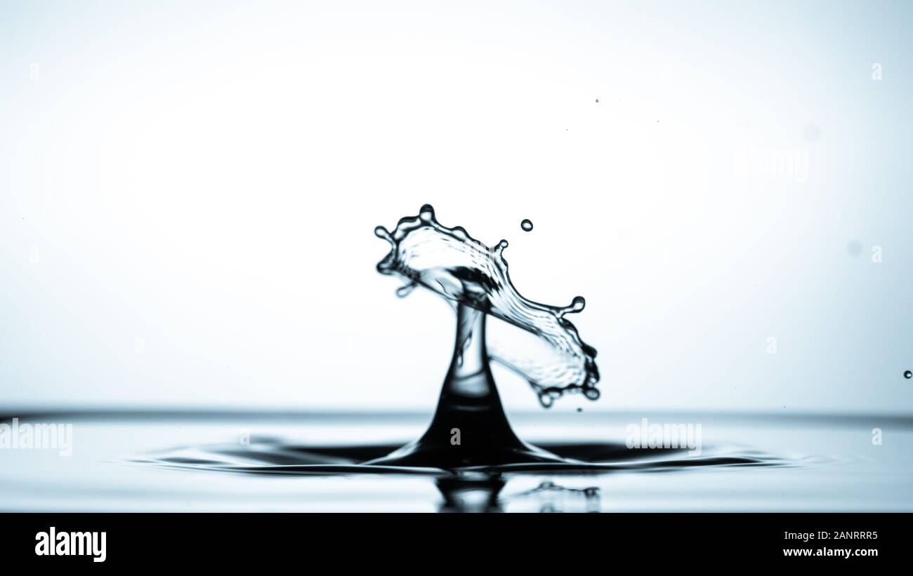 Close-up of a water drop falling on water surface Stock Photo - Alamy