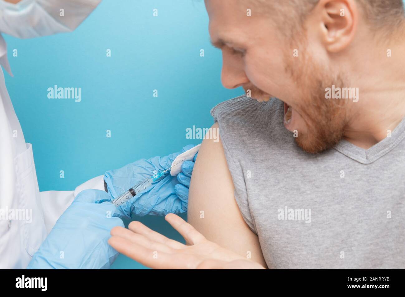 Man is afraid of nurse. Fear of syringe injections and vaccinations ...