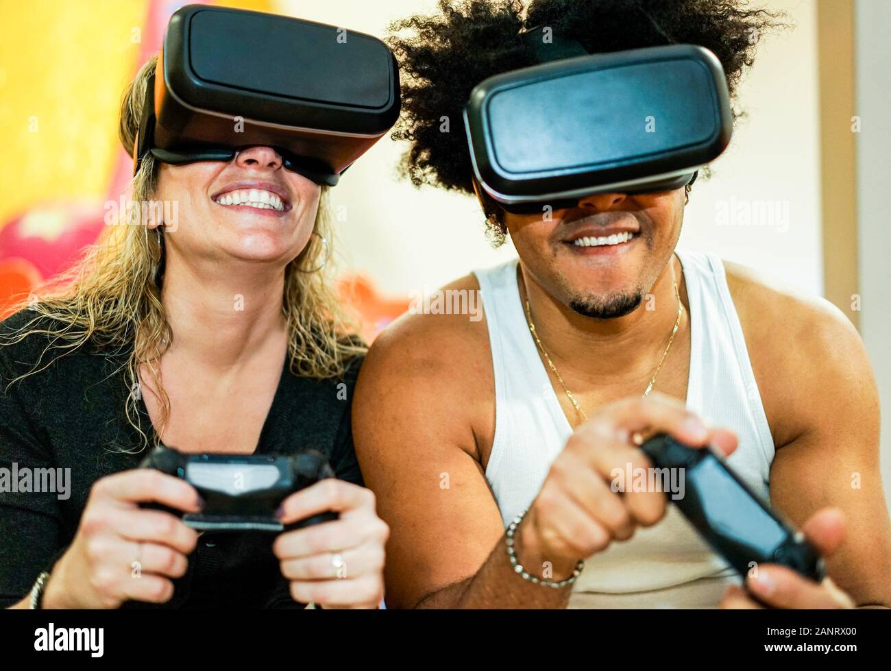 Diverse culture couple having fun playing video games with virtual ...