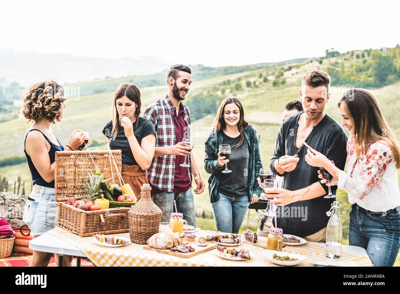 Happy adult friends eating at picnic lunch in italian vineyard outdoor ...