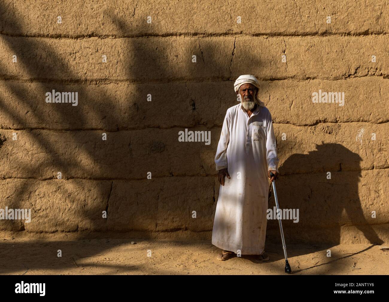 Old saudi man standing in front of a mud house, Najran Province, Najran ...