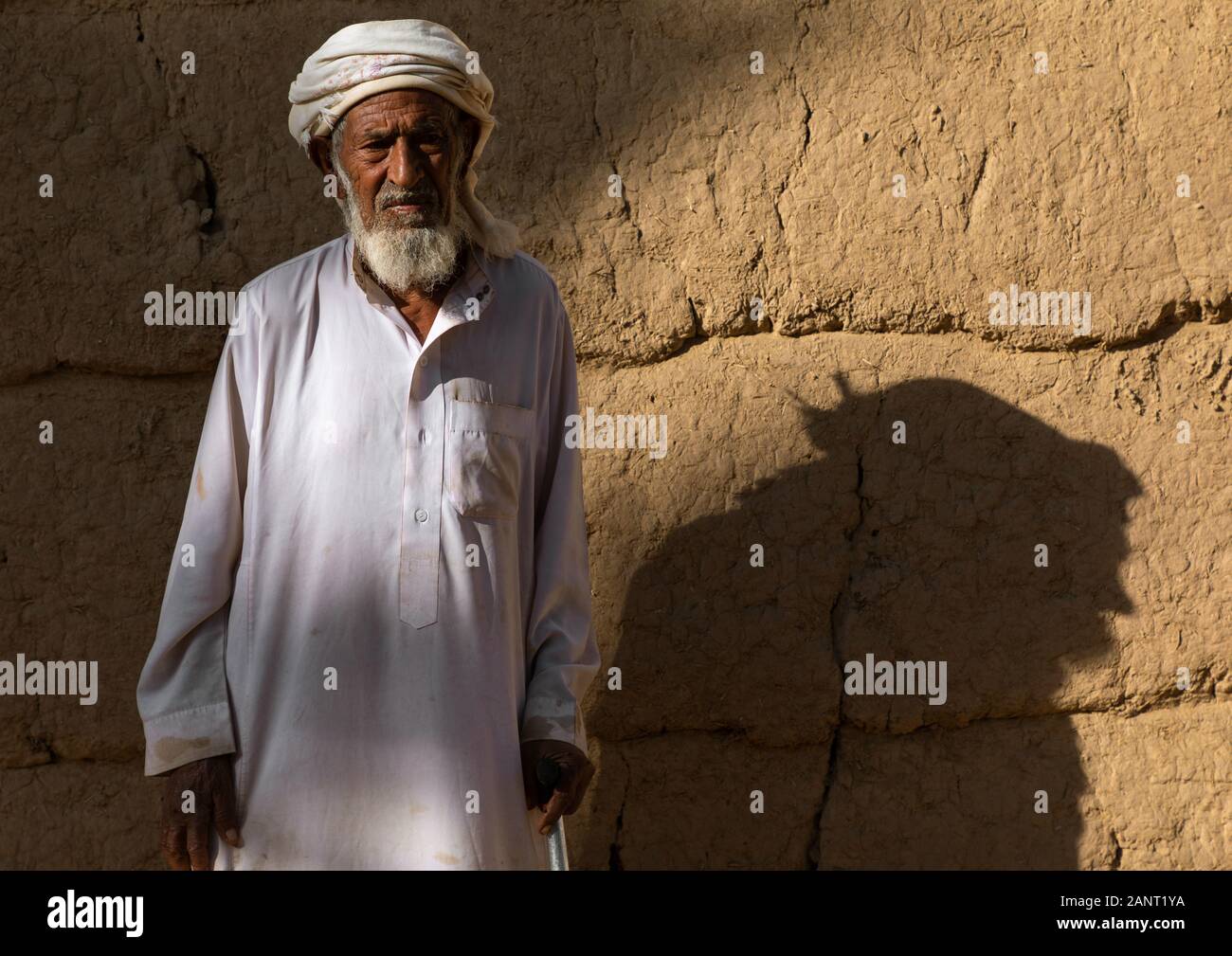 Old saudi man standing in front of a mud house, Najran Province, Najran ...