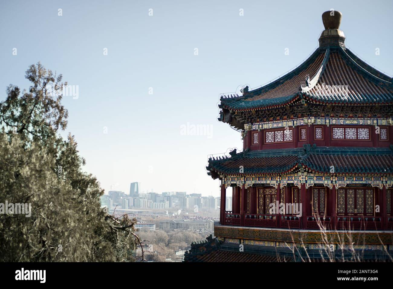 Traditional chinese pagoda in red blue and yellow, with a city as a ...