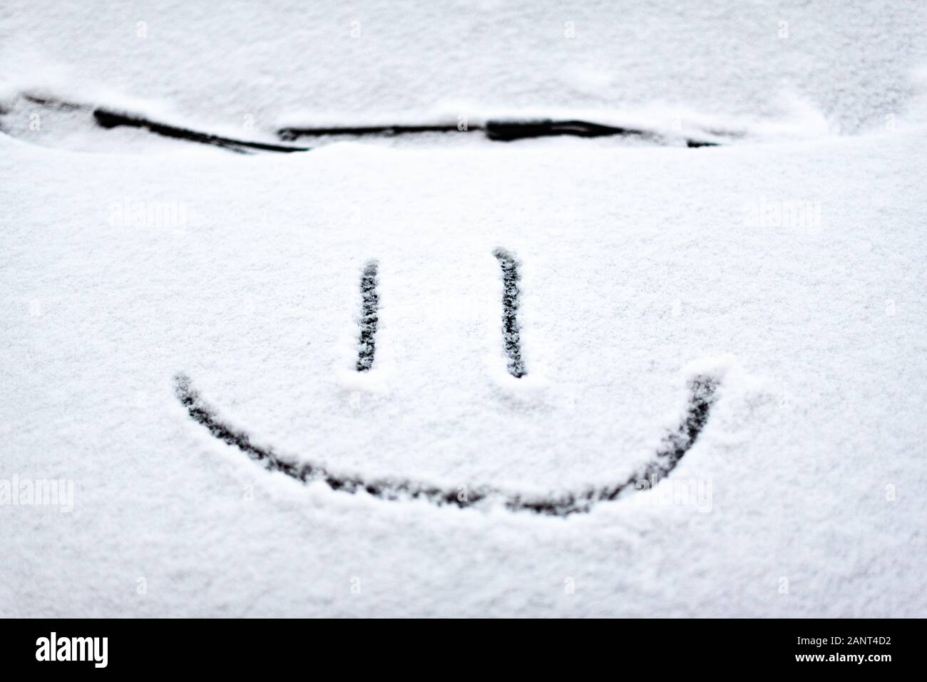 Snow background. Texture of wet snow with a cheerful smiley symbol ...