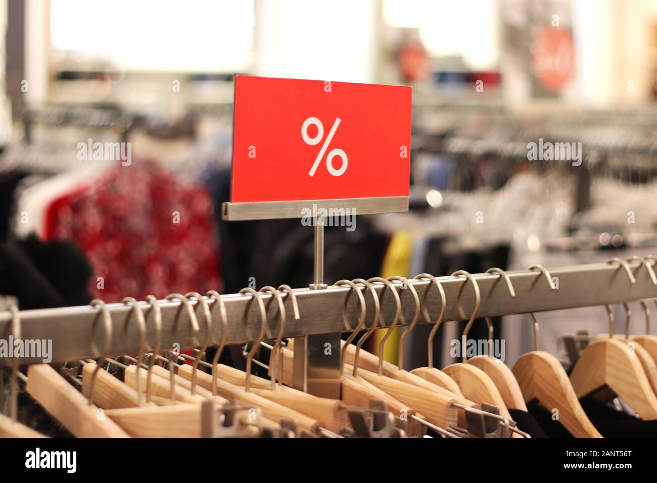 red percentage sign at a clothes rail in a department store, background ...