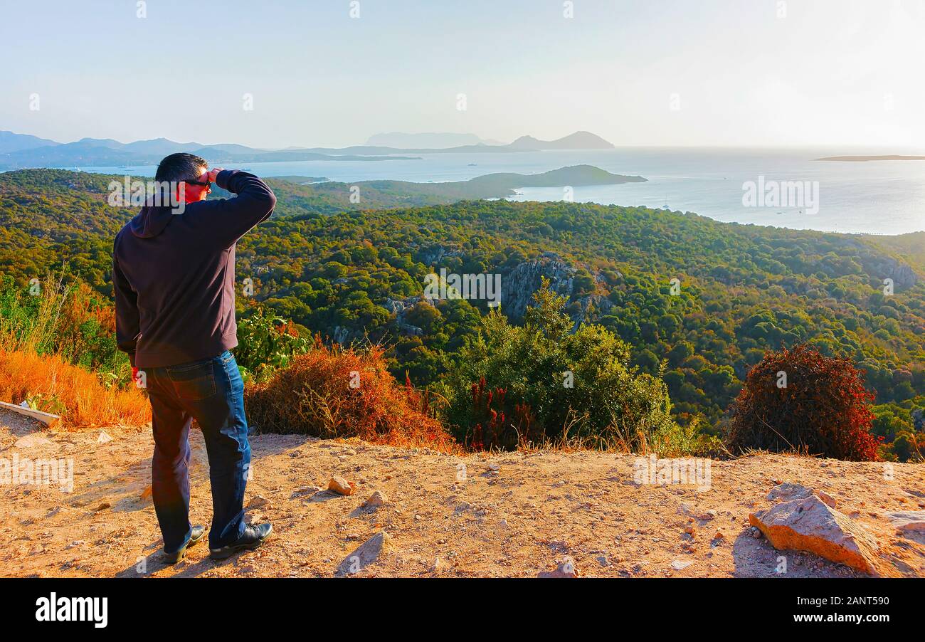 Man looking at sunrise in Costa Smeralda resort Mediterranean sea ...