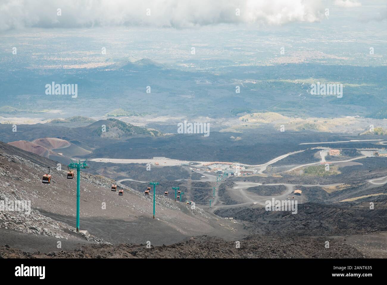 Top of crater Mount Etna volcano, frozen cold lava smokes, thick clouds ...