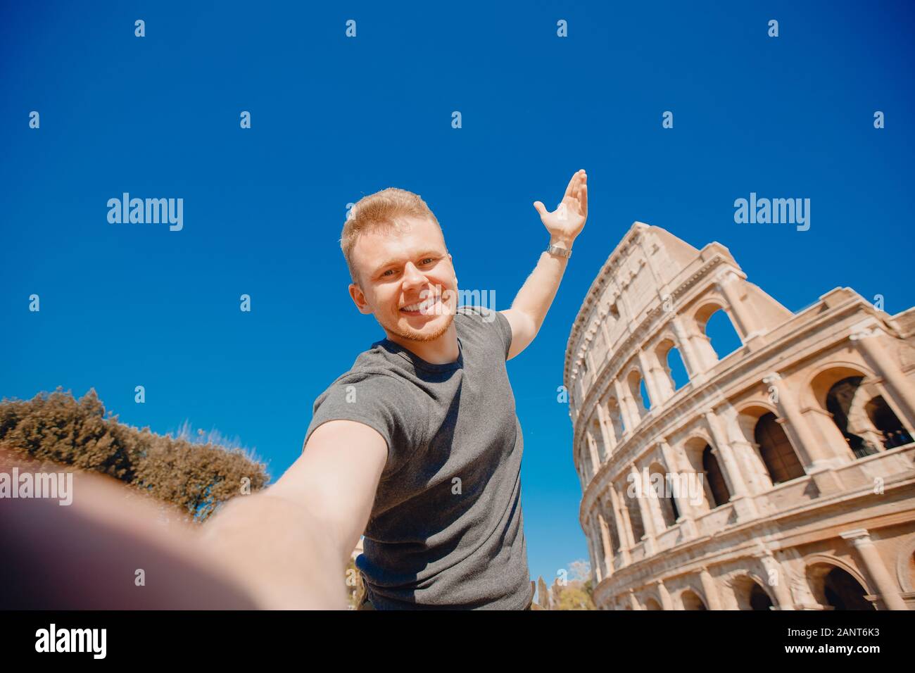 Happy young man making selfie in front of Colosseum in Rome, Italy ...