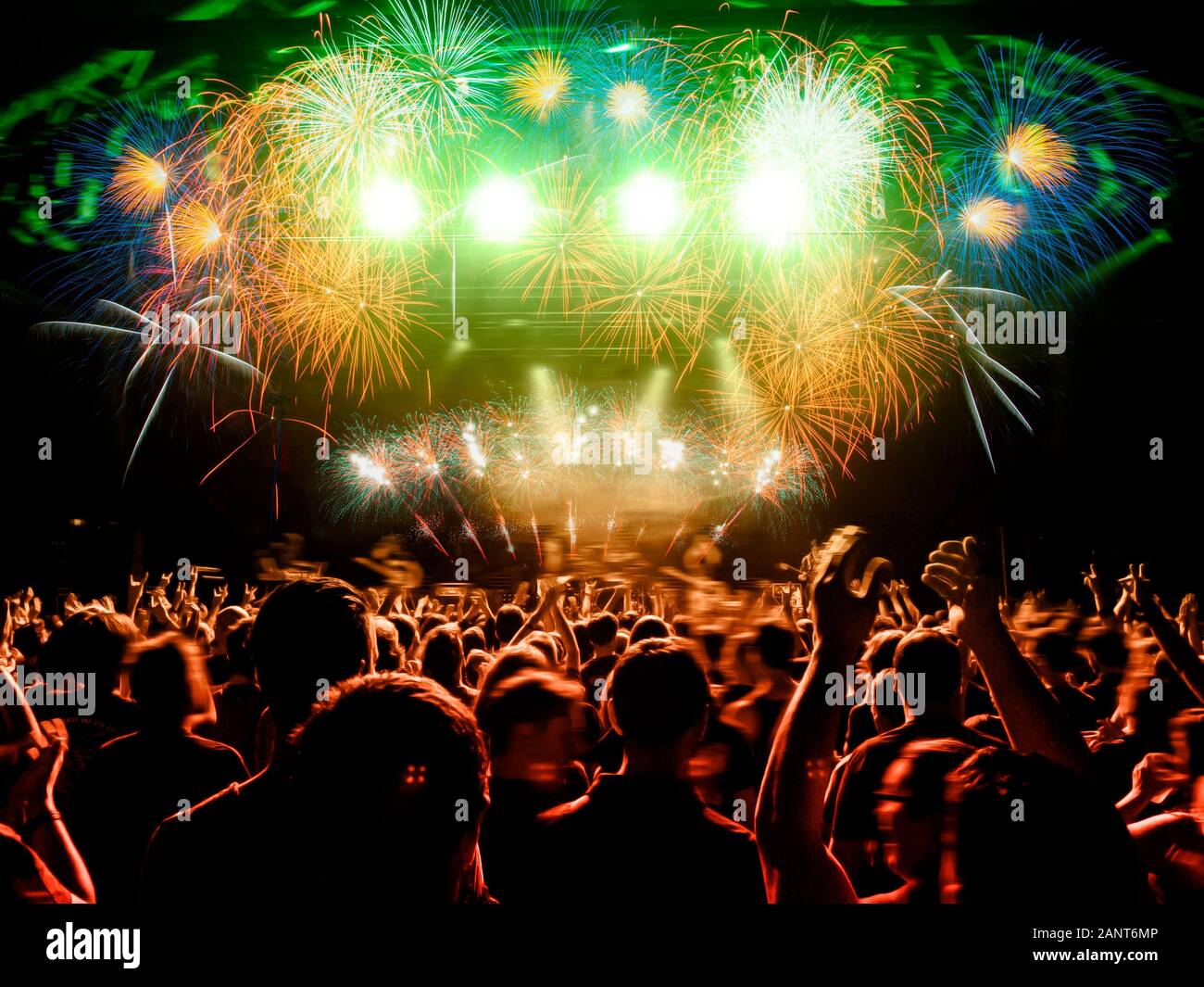 Colourful concert stage inside a venue, people silhouettes are visible ...