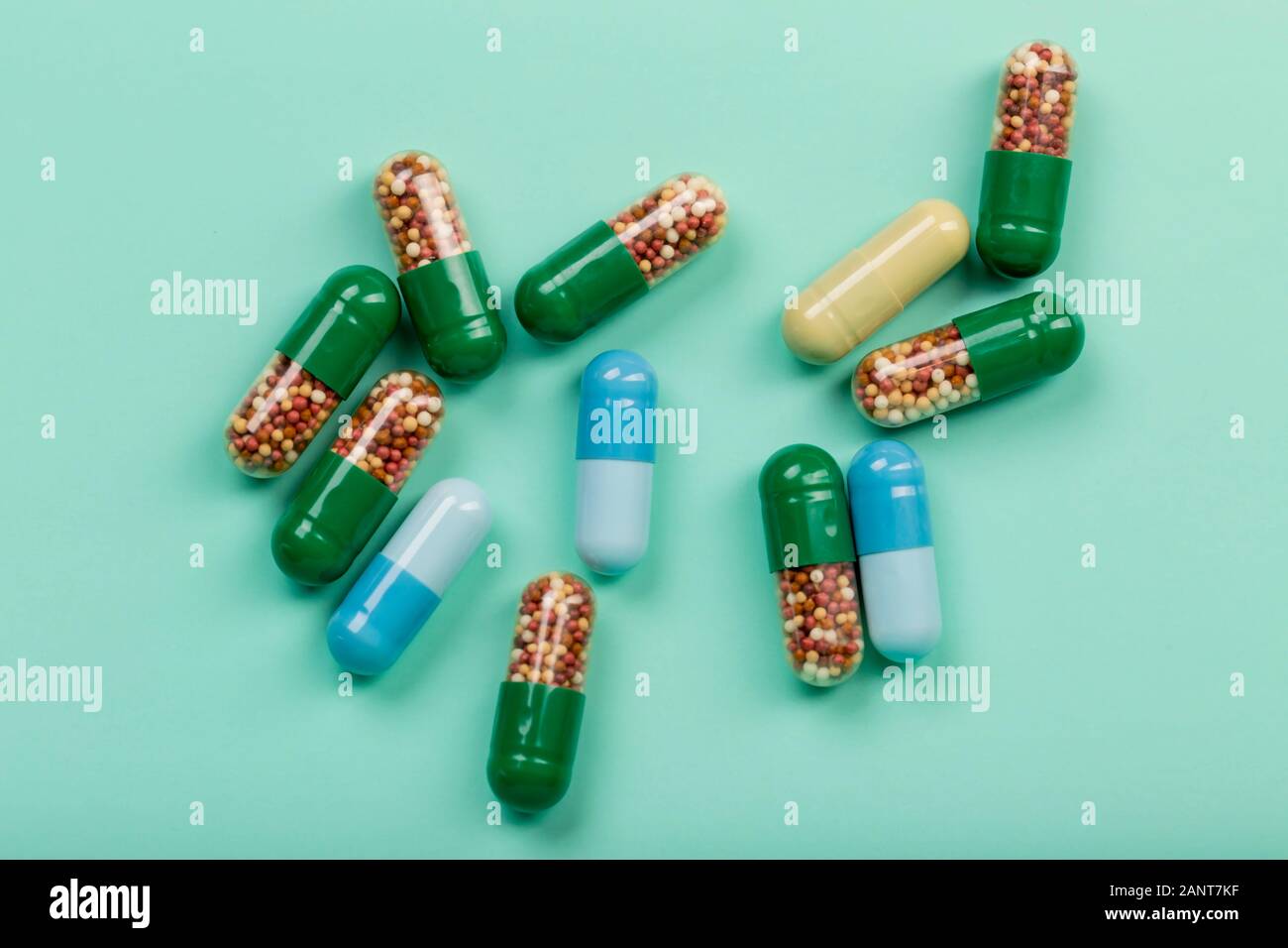 transparent green capsules with micro granules on a colored background ...