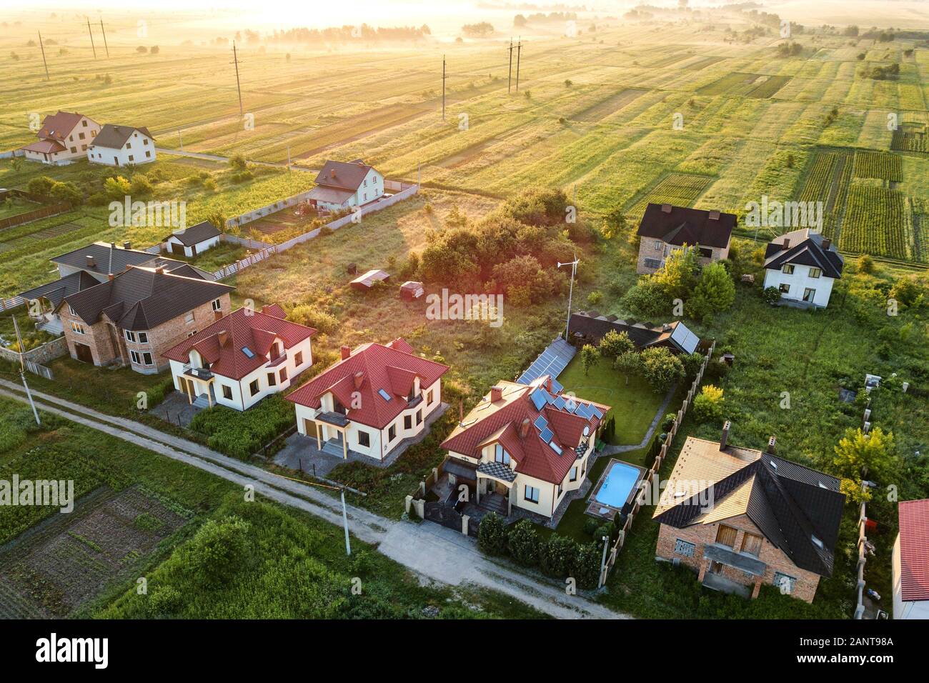 Aerial view of rural residential area with private homes between green ...