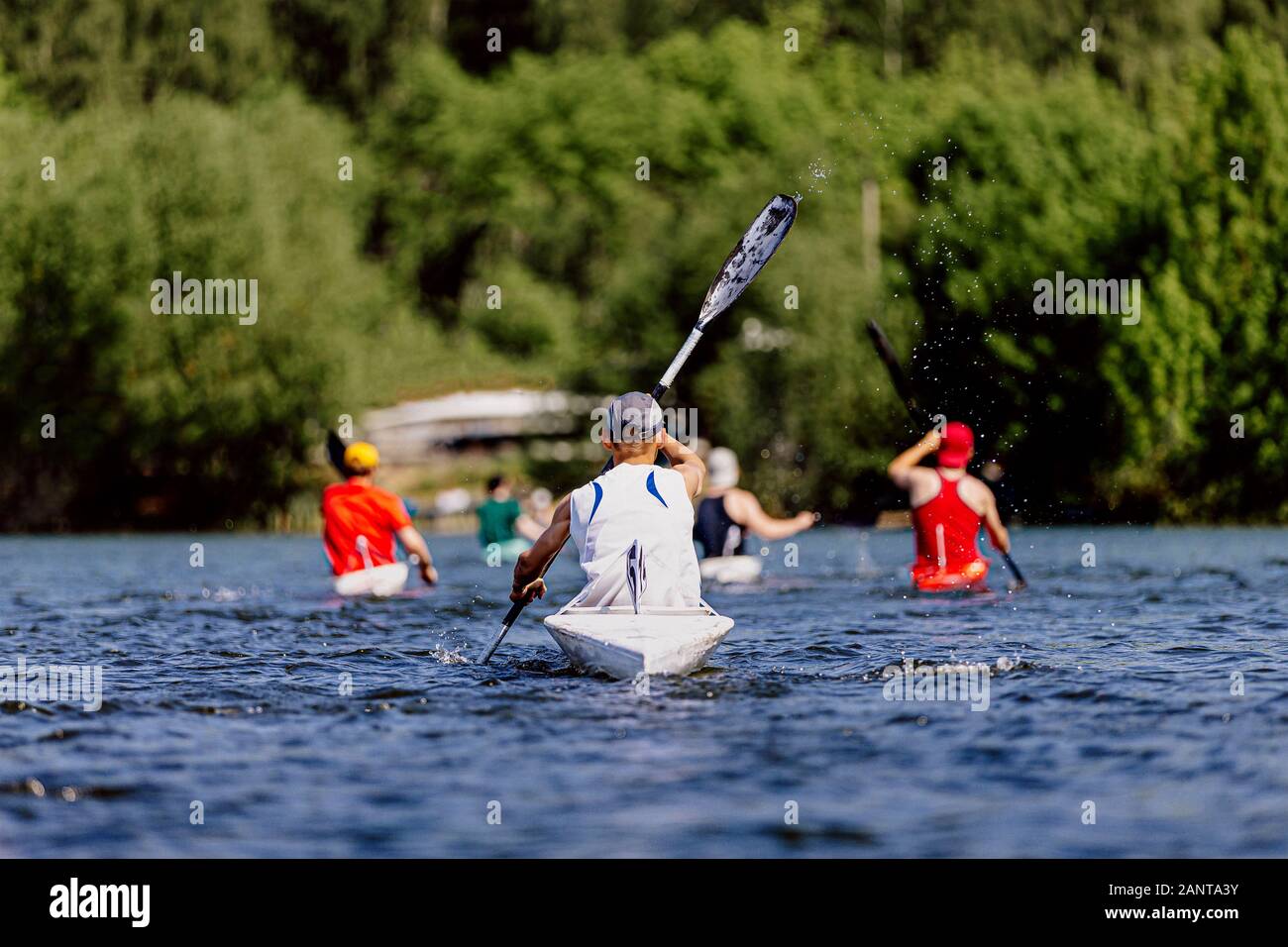 back group young athletes rowers kayaking on lake Stock Photo - Alamy