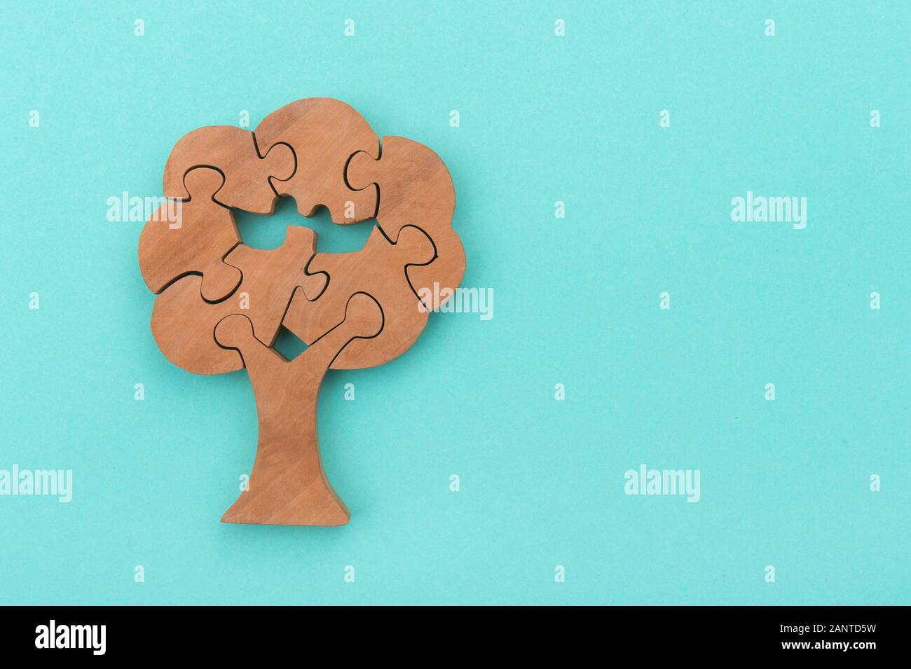 Wooden tree puzzle over green background Stock Photo - Alamy